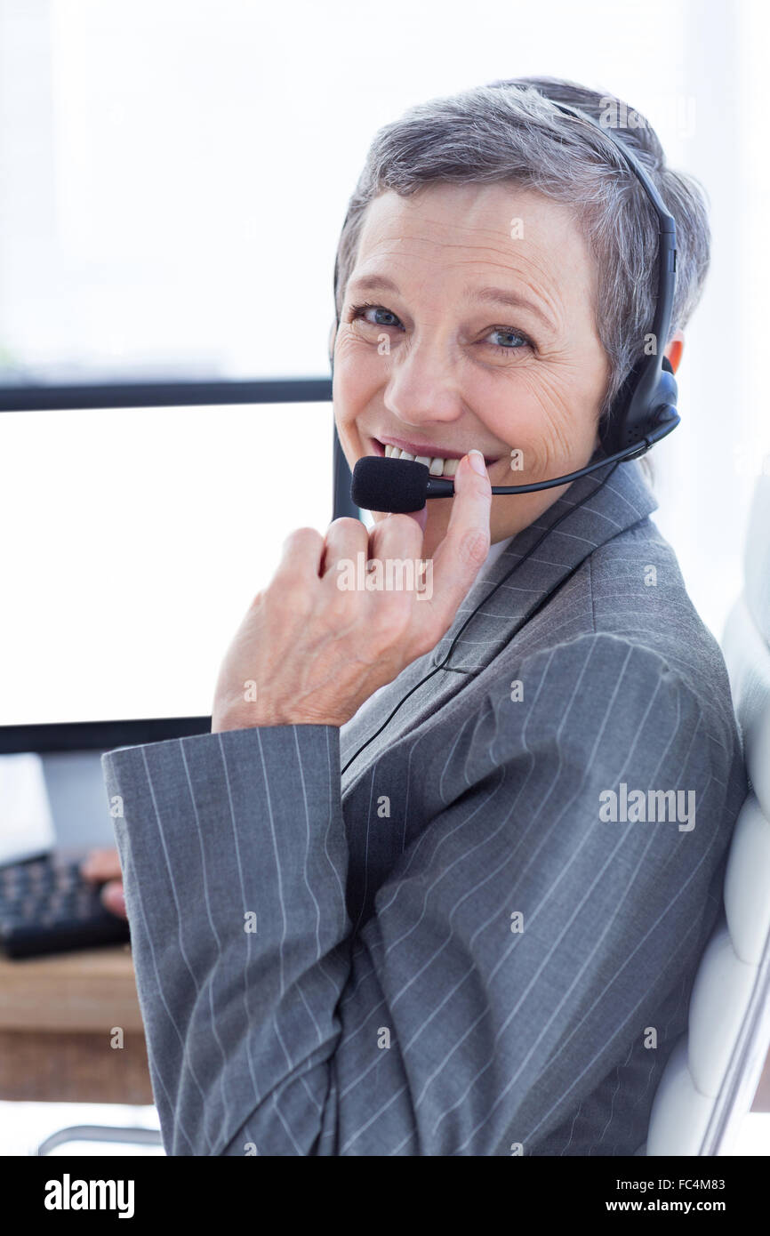 Smiling businesswoman phoning and using computer Stock Photo - Alamy