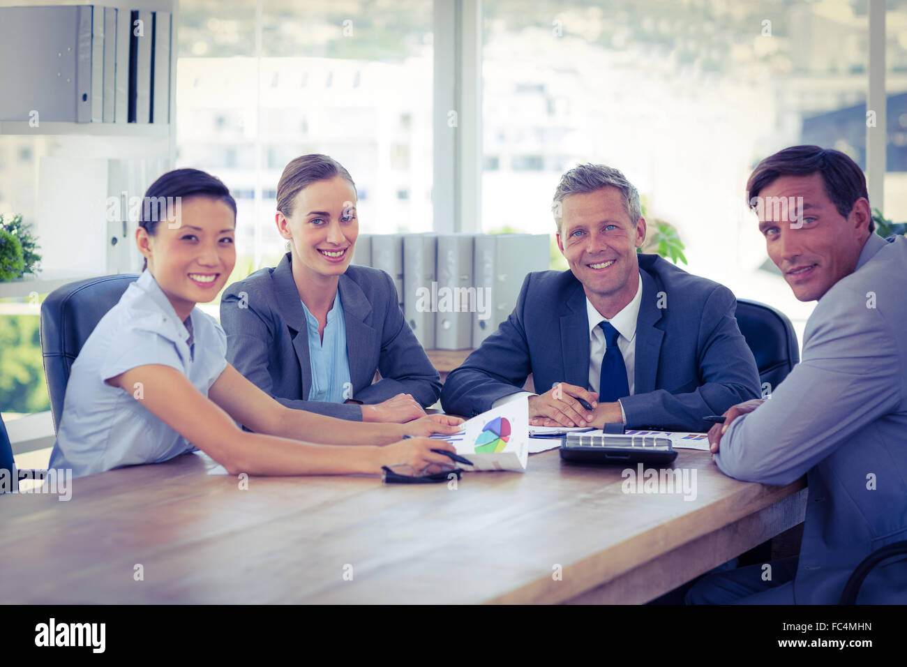 Business people looking at camera during meeting Stock Photo - Alamy