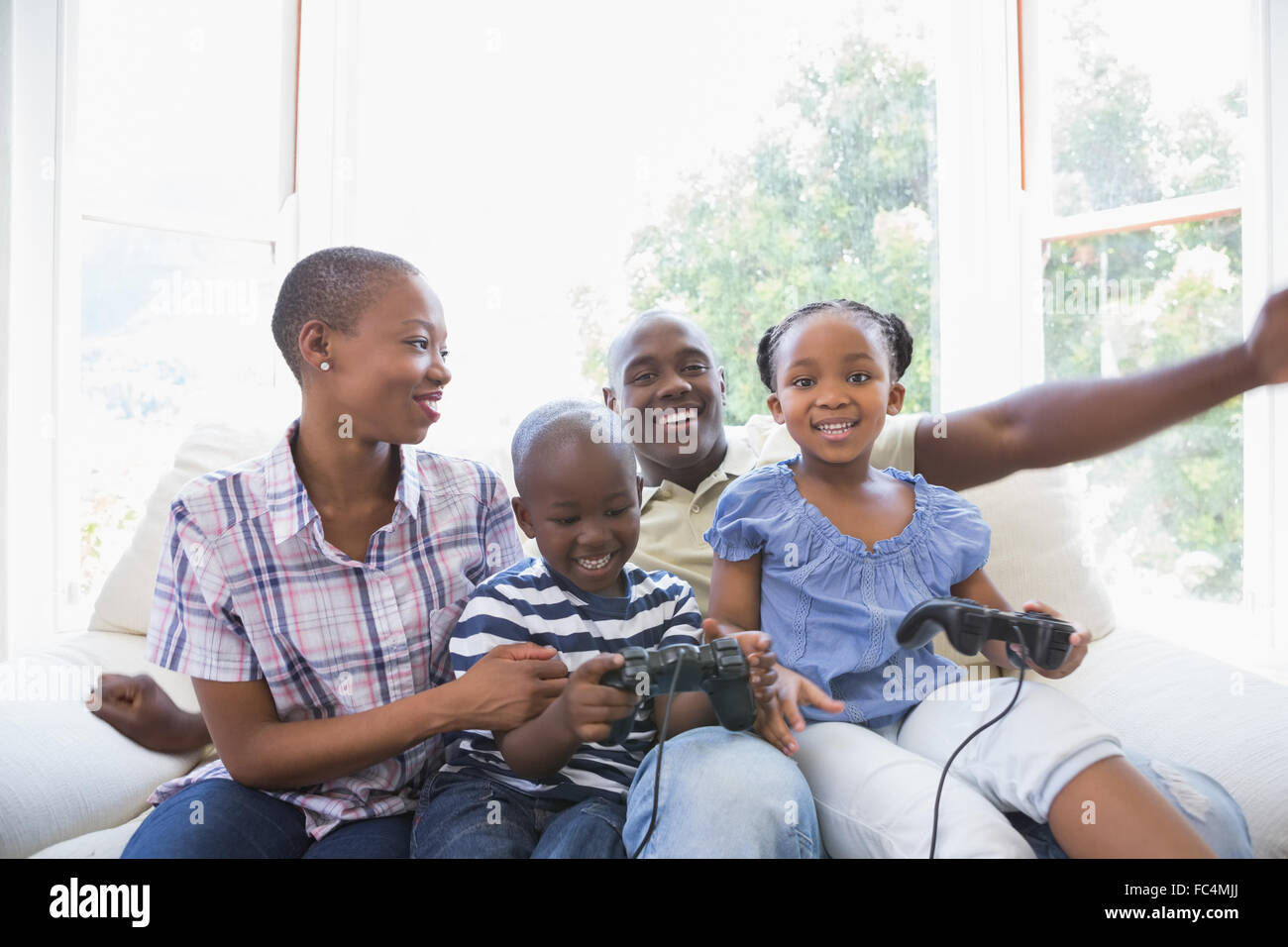 Happy smiling family playing video games together Stock Photo - Alamy