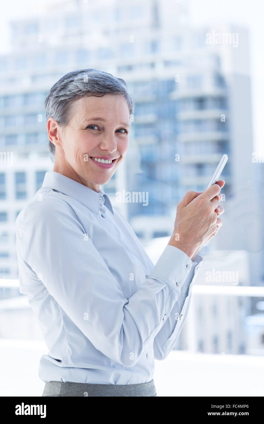 Businesswoman sending a text message in the office Stock Photo - Alamy