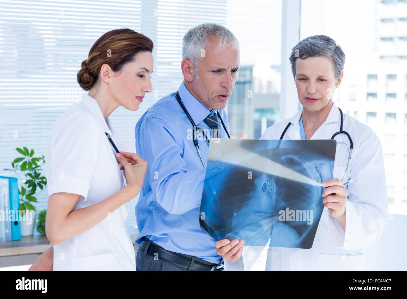 Concentrated medical colleagues examining x-ray together Stock Photo ...
