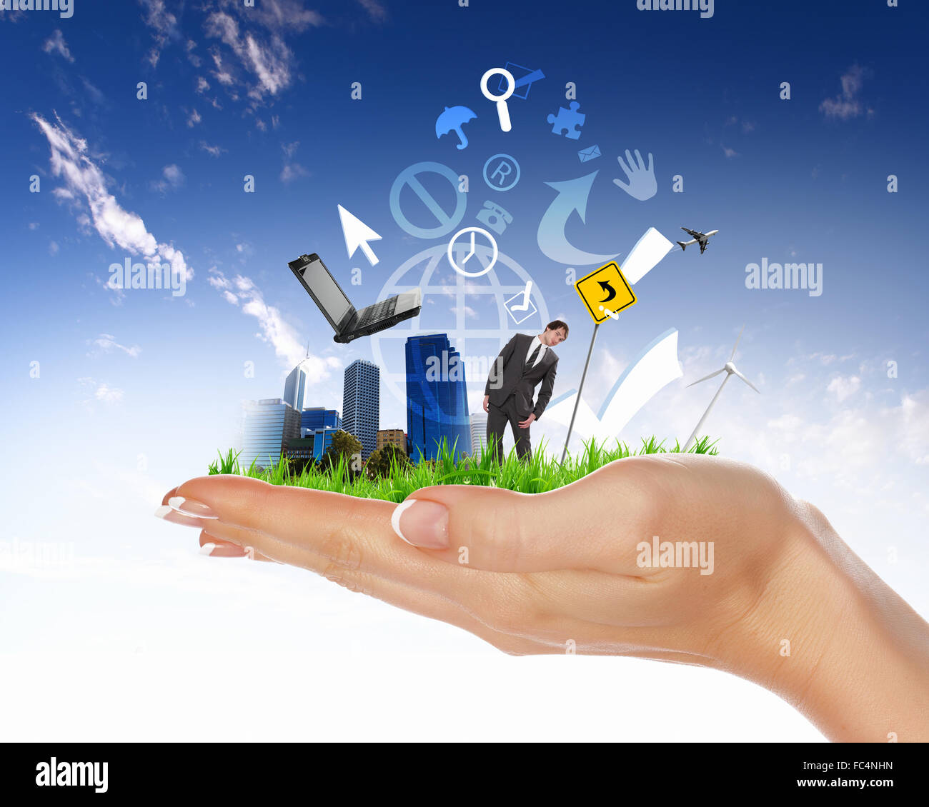 human hand holding a city on green grass hill Stock Photo - Alamy