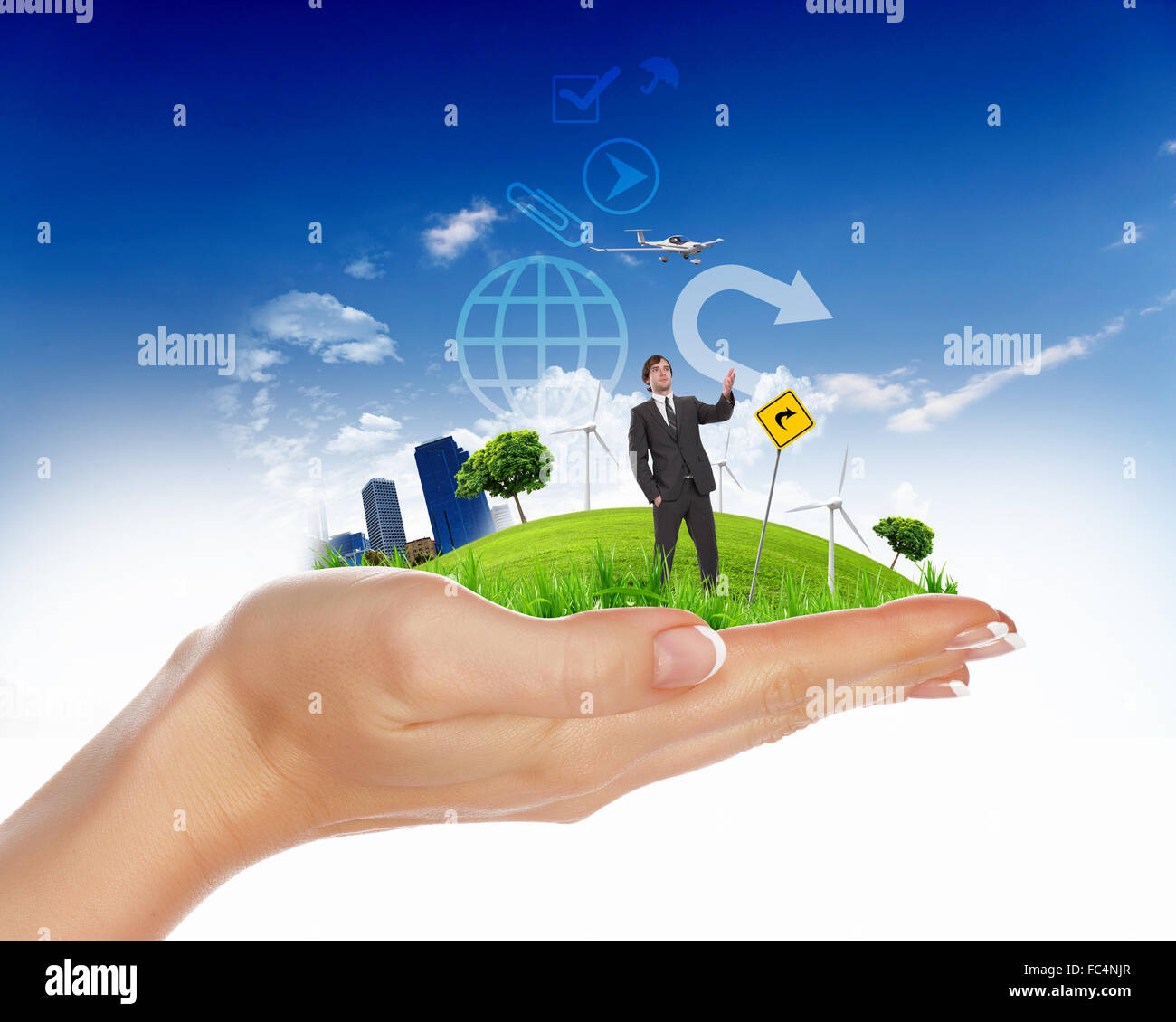 human hand holding a city on green grass hill Stock Photo - Alamy