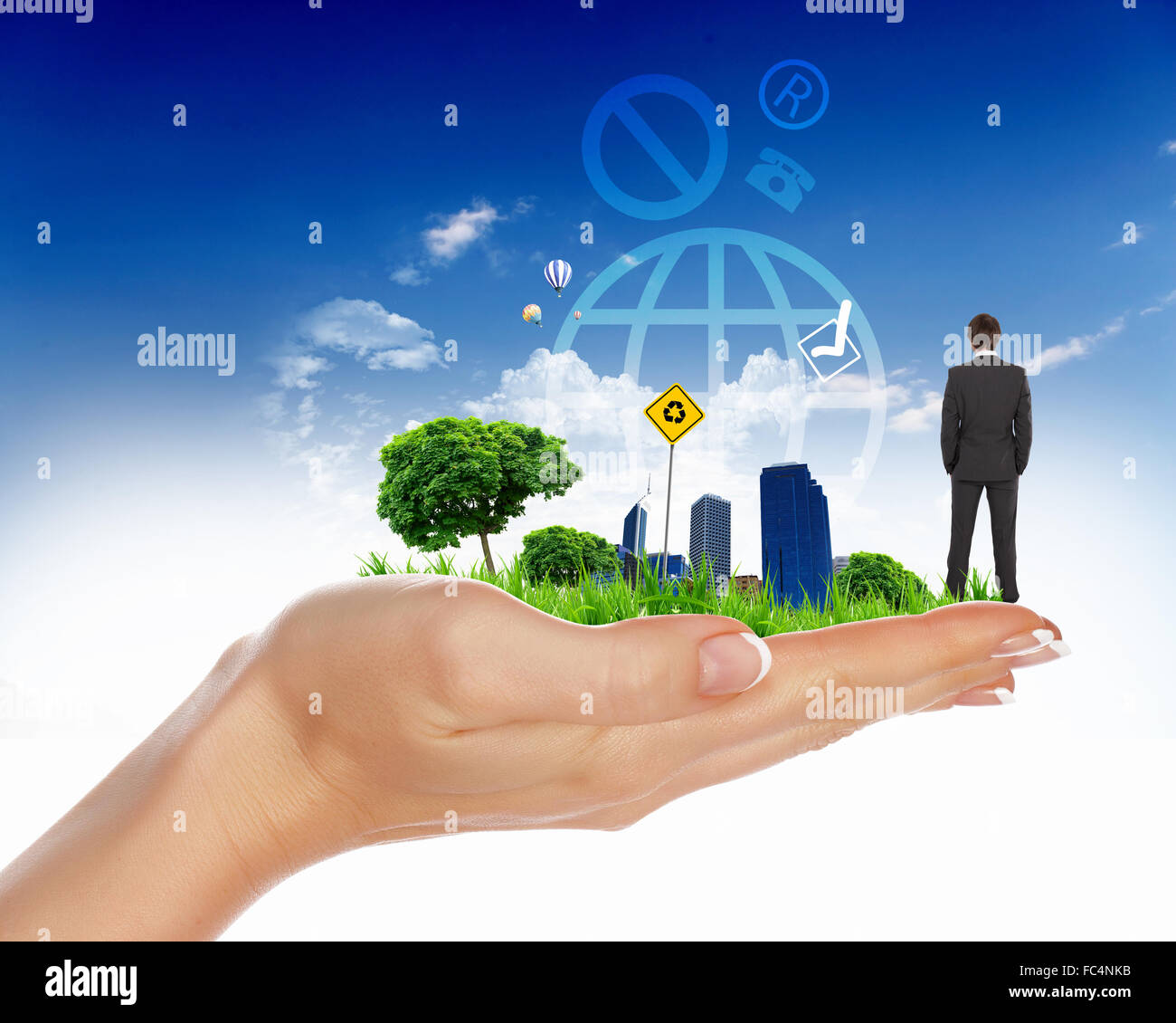 human hand holding a city on green grass hill Stock Photo - Alamy