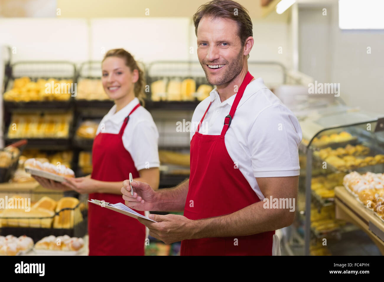 Portrait of a two smiling bakers looking at camera Stock Photo - Alamy