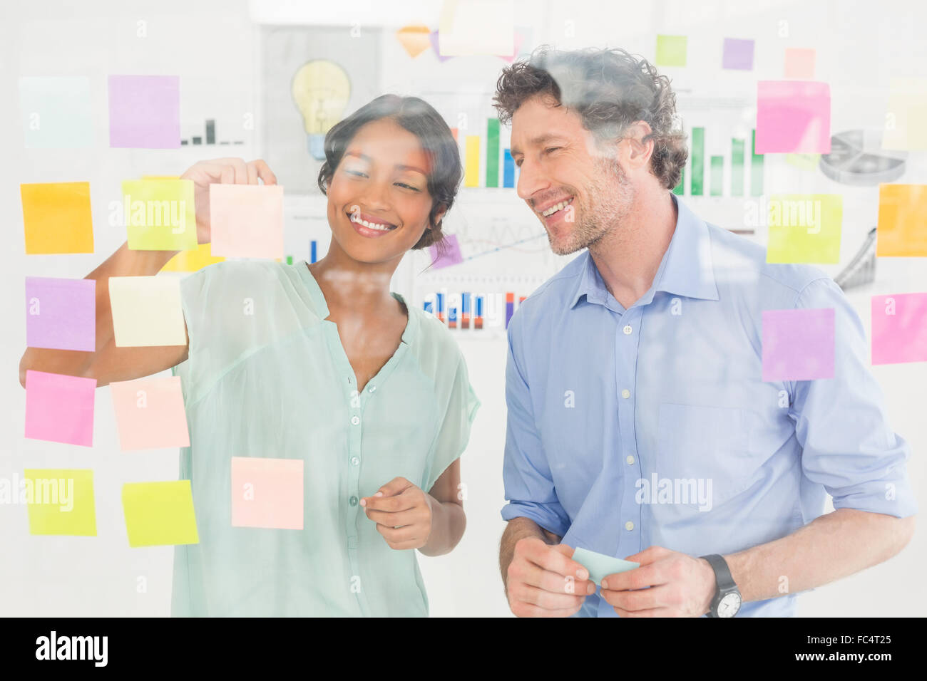 Puzzled business team looking post its on the wall Stock Photo - Alamy