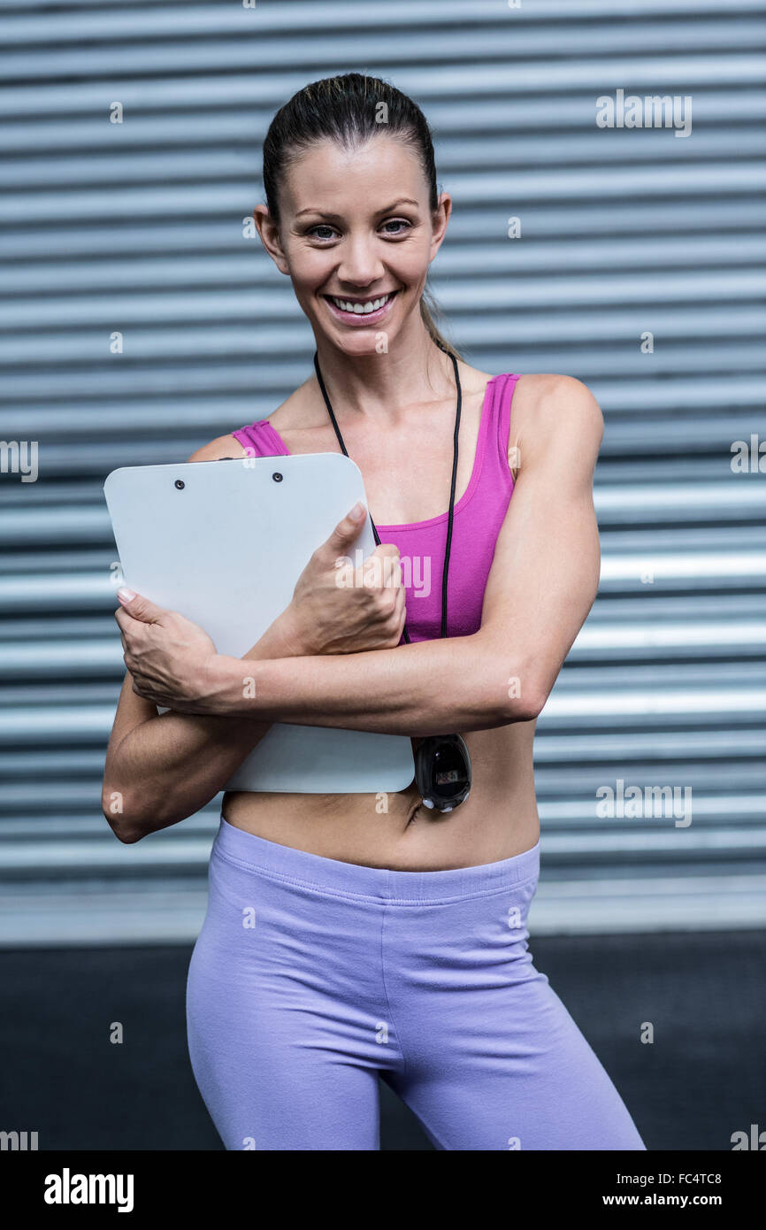 Smiling female coach with a clipboard and stopwatch Stock Photo - Alamy