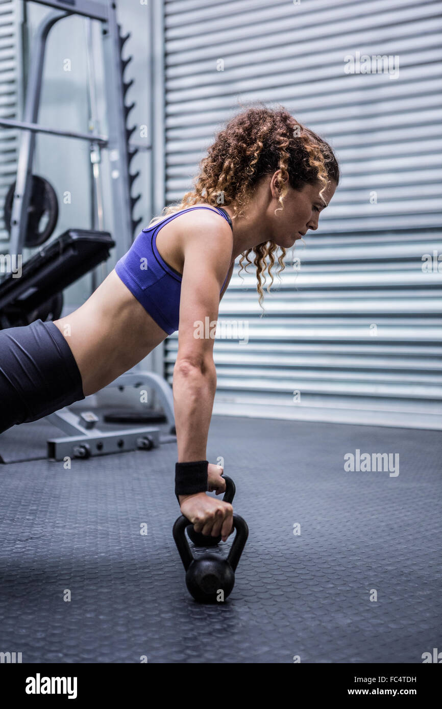 Muscular woman doing push-ups with kettlebells Stock Photo - Alamy