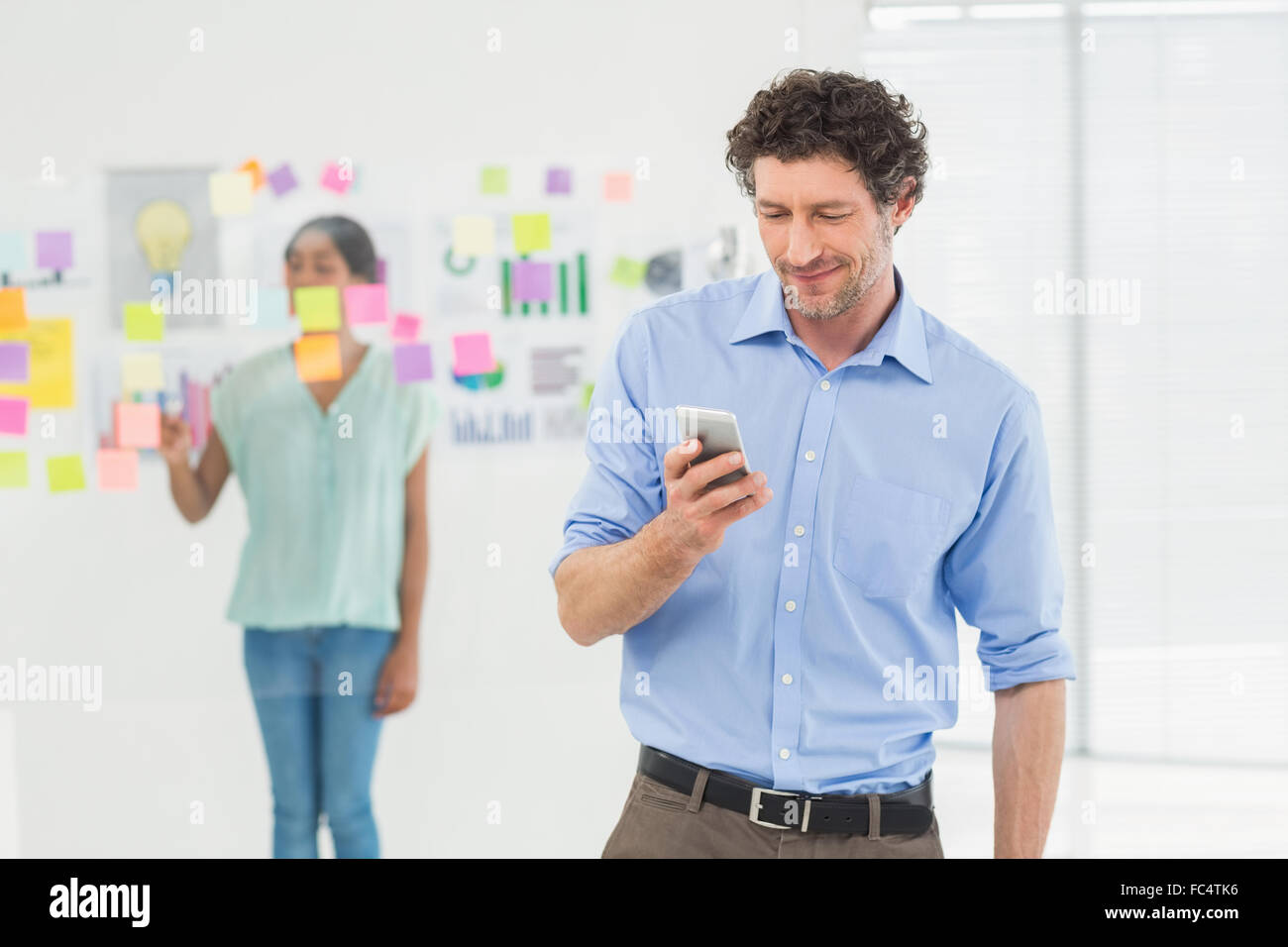 Businessman calling while his colleague posing Stock Photo - Alamy