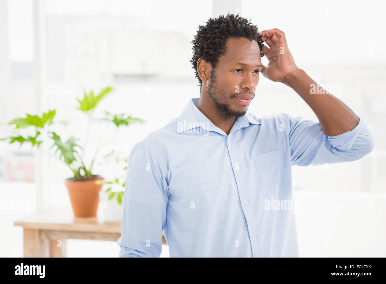 Young thinking businessman scratching his head Stock Photo - Alamy