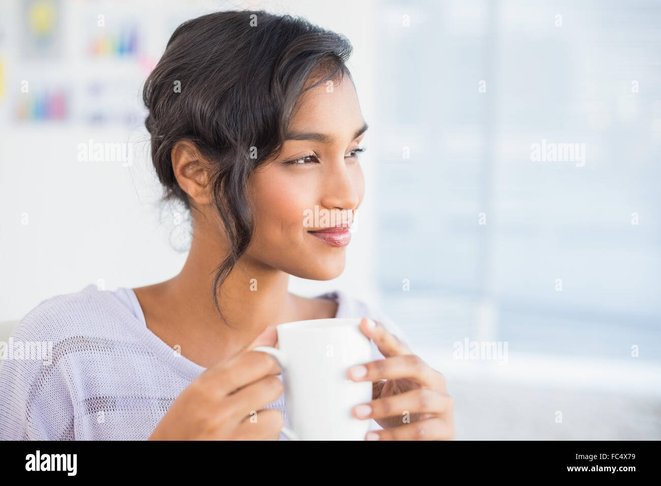 Casual businesswoman having a coffee at desk Stock Photo - Alamy