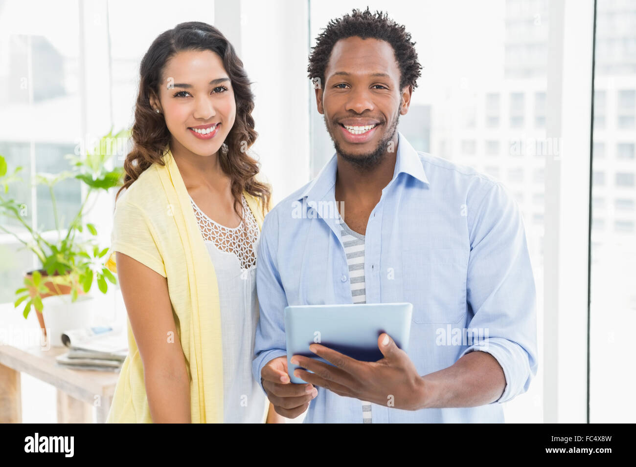 Young smiling business people holding and using a digital tablet Stock ...