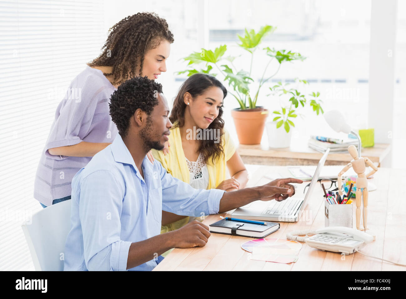 Colleagues using laptop together and pointing the screen Stock Photo ...