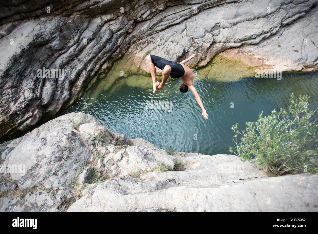 Young man does backflip into a natural pool in Montanejos Stock Photo ...