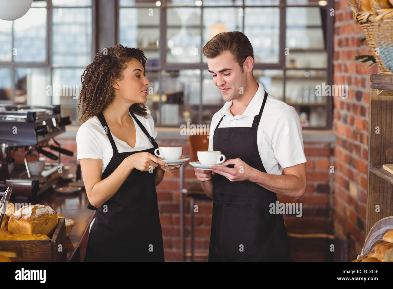 Smiling waiter and waitress holding cup of coffee Stock Photo - Alamy