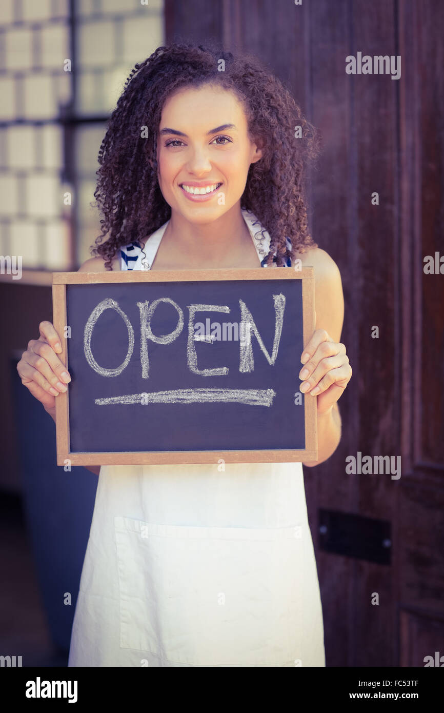 Smiling waitress showing chalkboard with open sign Stock Photo - Alamy