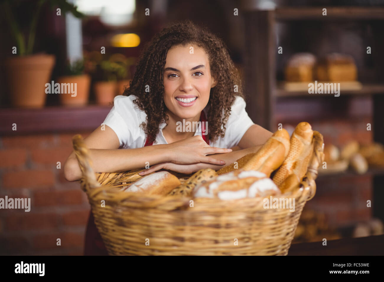 Smiling waitress bended over a basket of bread Stock Photo - Alamy