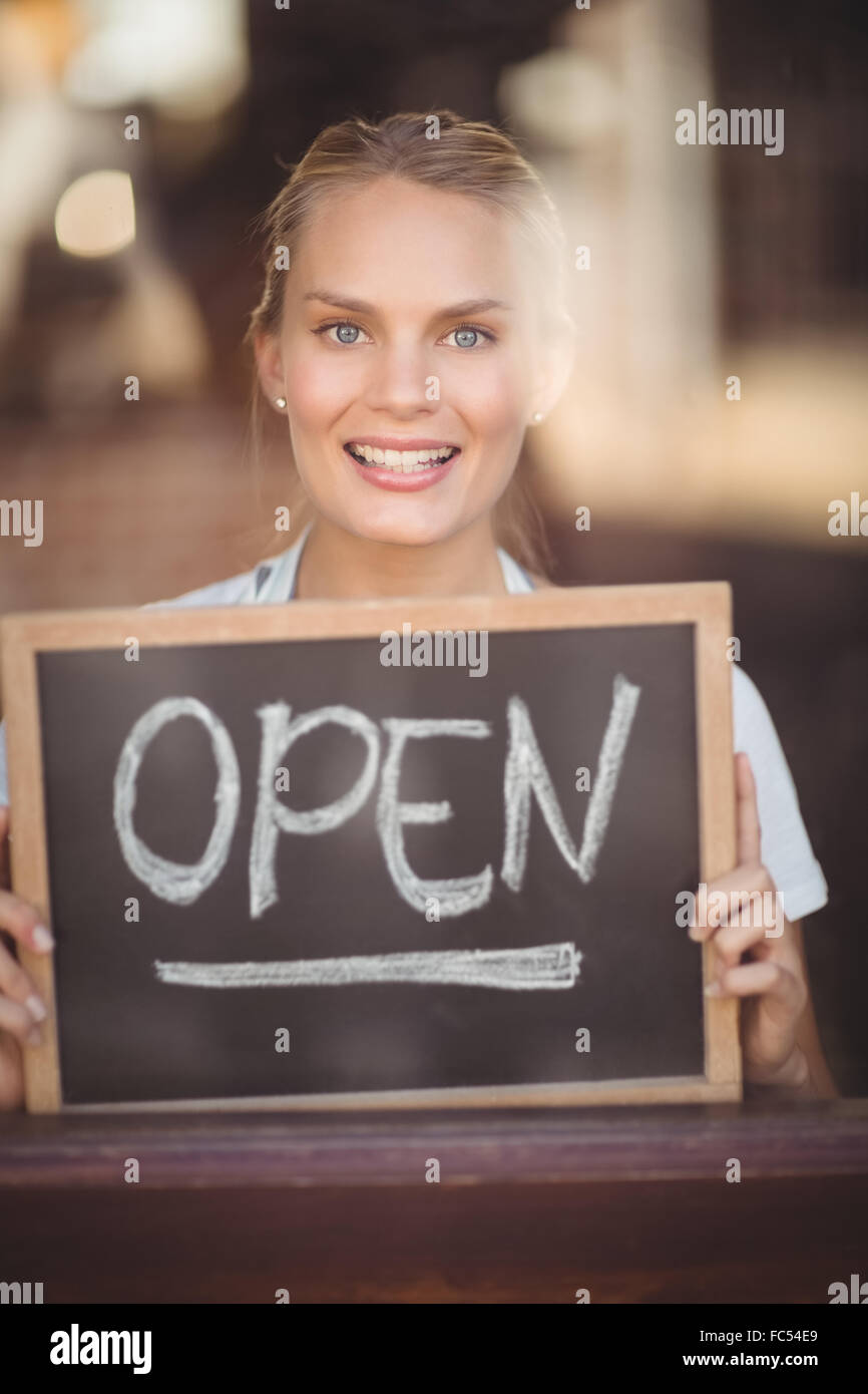 Smiling blonde waitress showing chalkboard with open sign Stock Photo ...