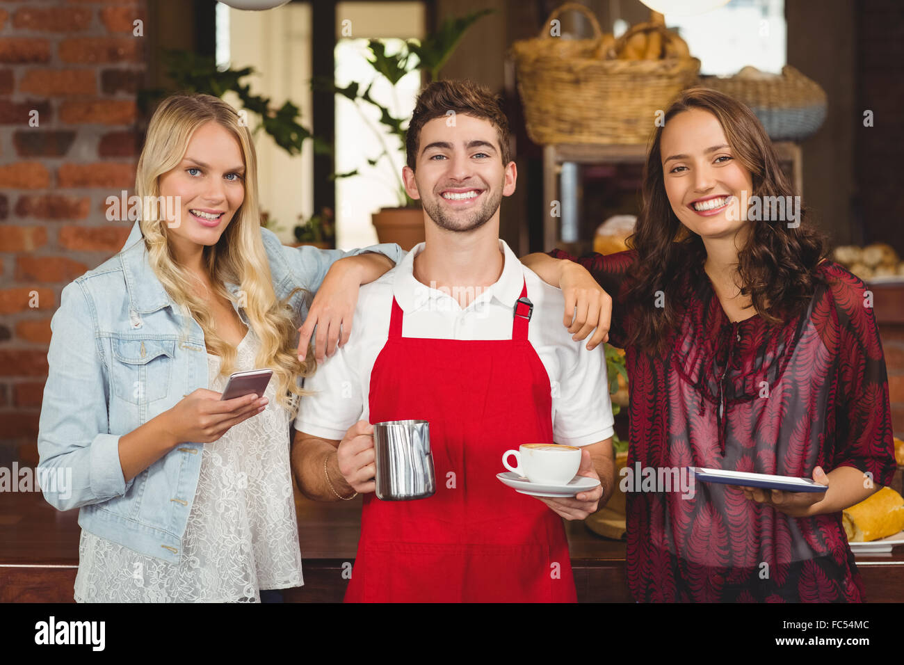 Smiling waiter and customers looking at the camera Stock Photo - Alamy
