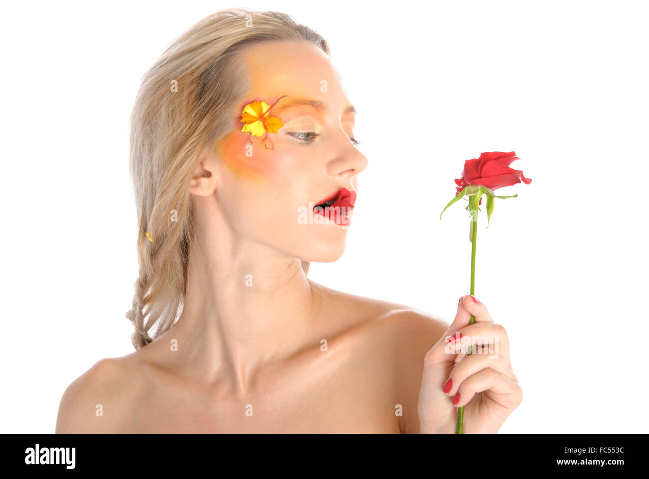 Young woman bites red flower Stock Photo - Alamy
