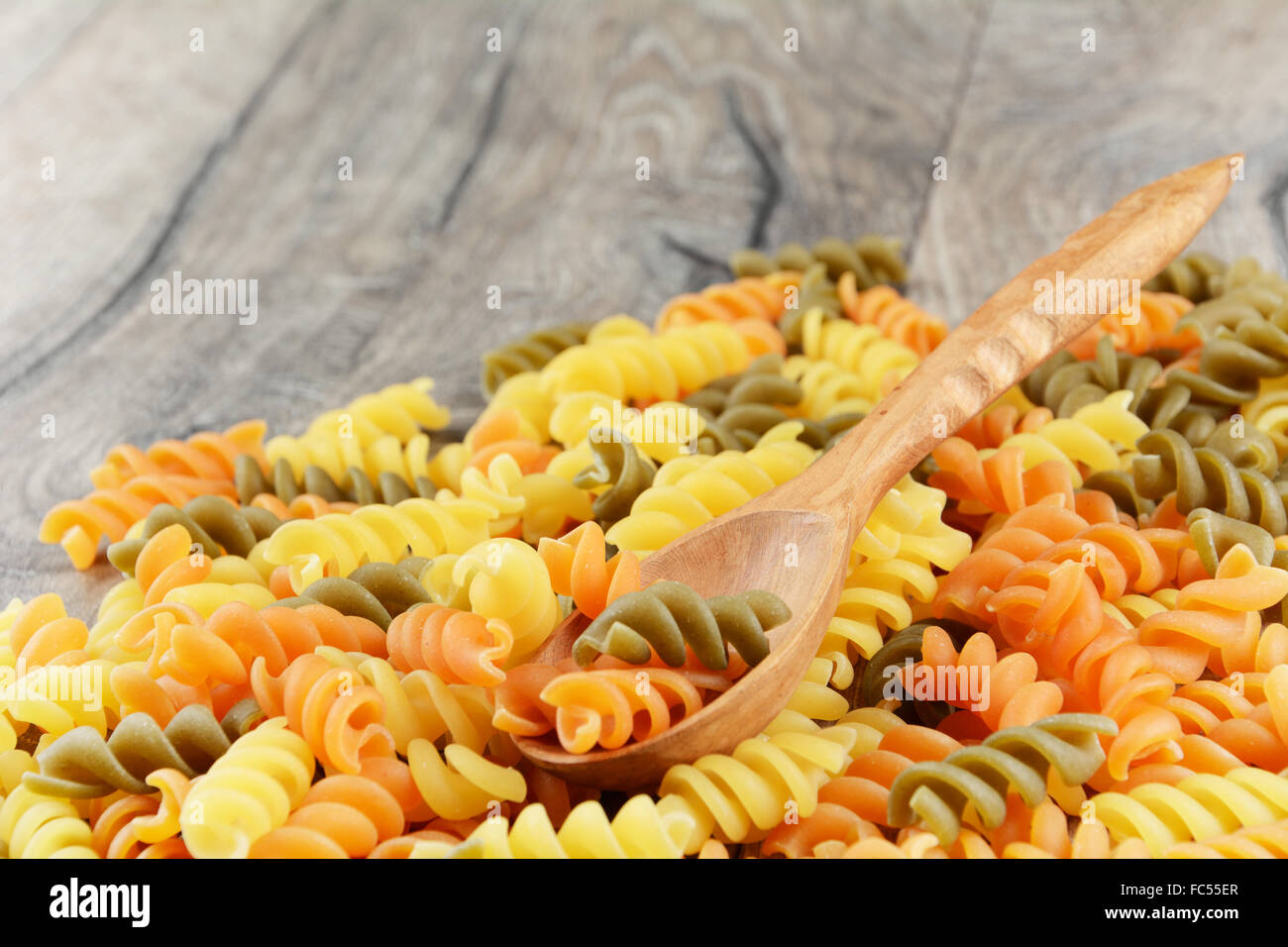 Raw eliche tricolori pasta background Stock Photo - Alamy