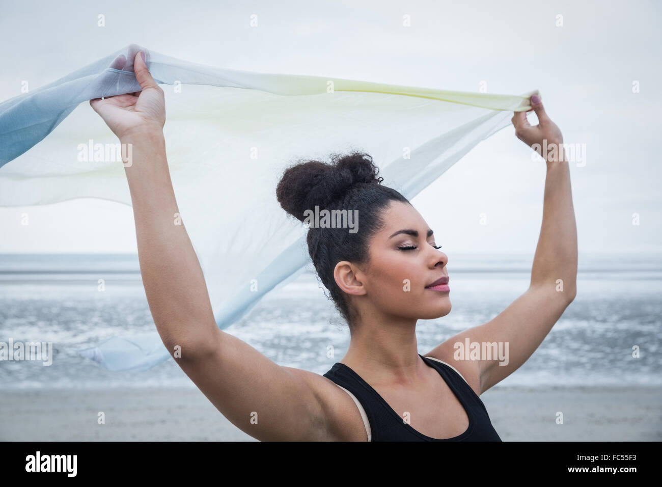 Fit girl standing with scarf blowing in wind Stock Photo - Alamy
