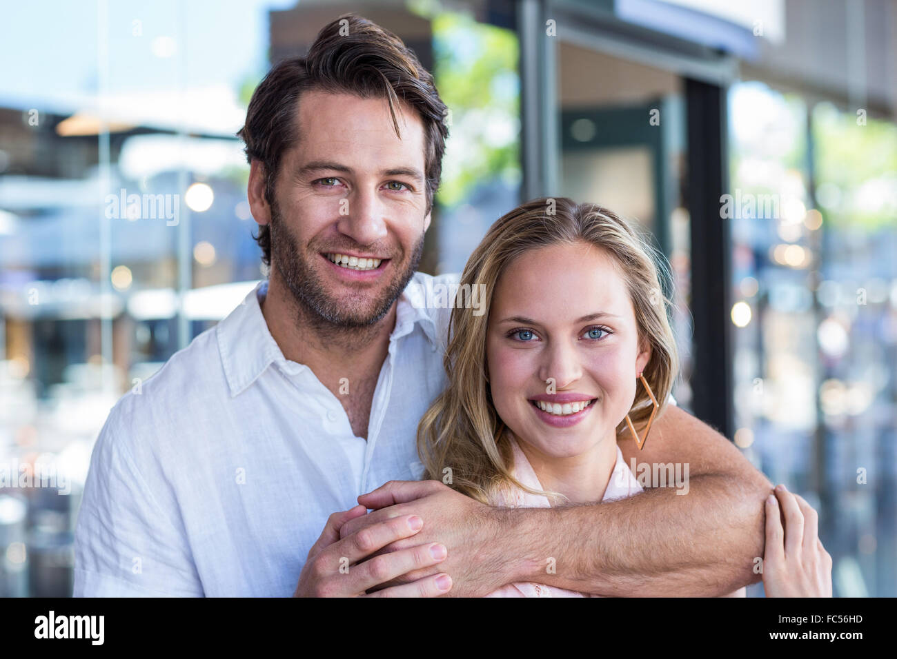 Smiling man putting arm around his girlfriend Stock Photo - Alamy