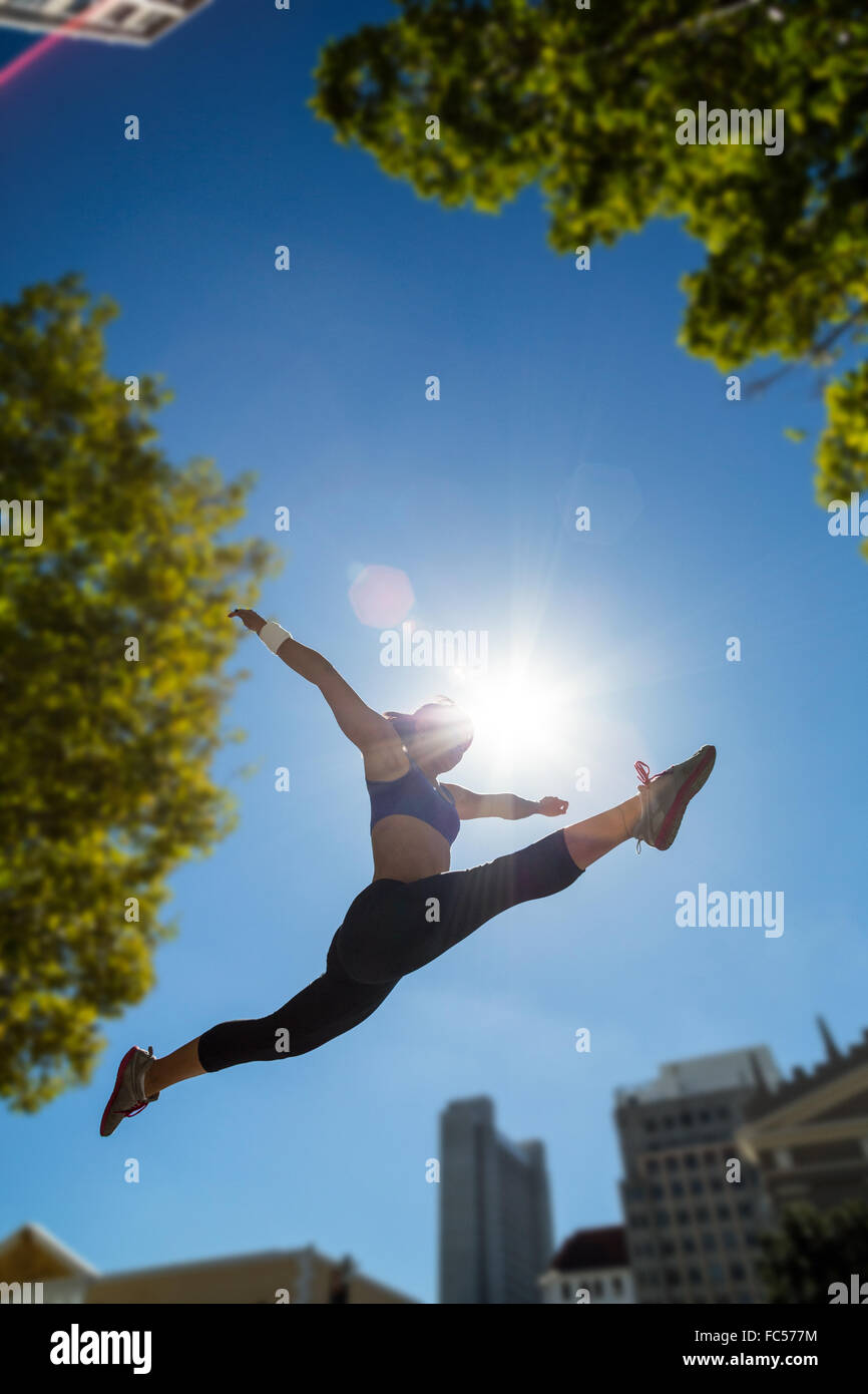 Athletic woman jumping in the air and doing split Stock Photo - Alamy