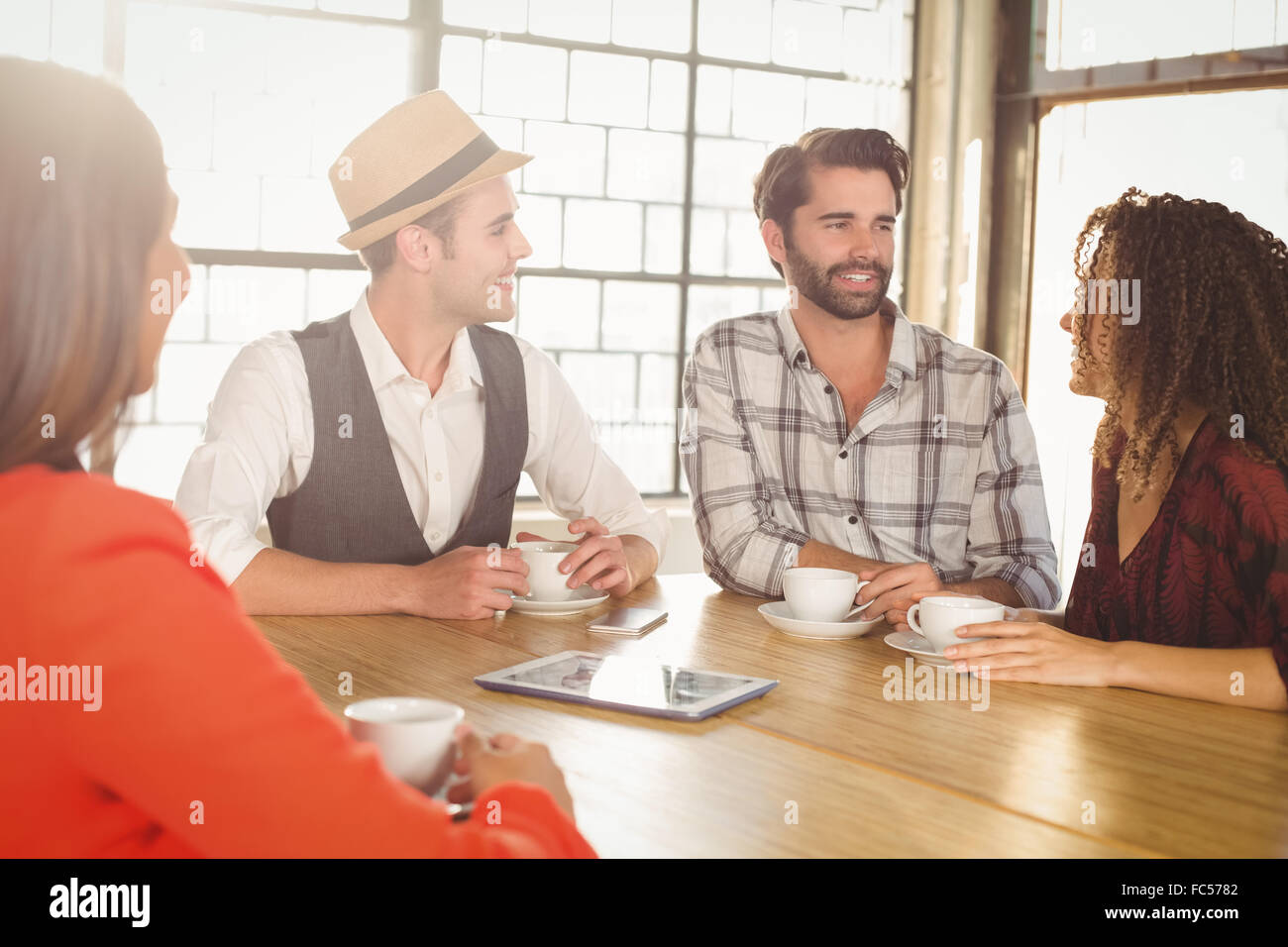 Smiling friends talking and having coffee together Stock Photo - Alamy