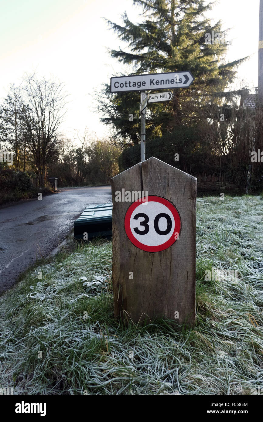 Rural speed limit sign mounted on a large oak post in rural ...
