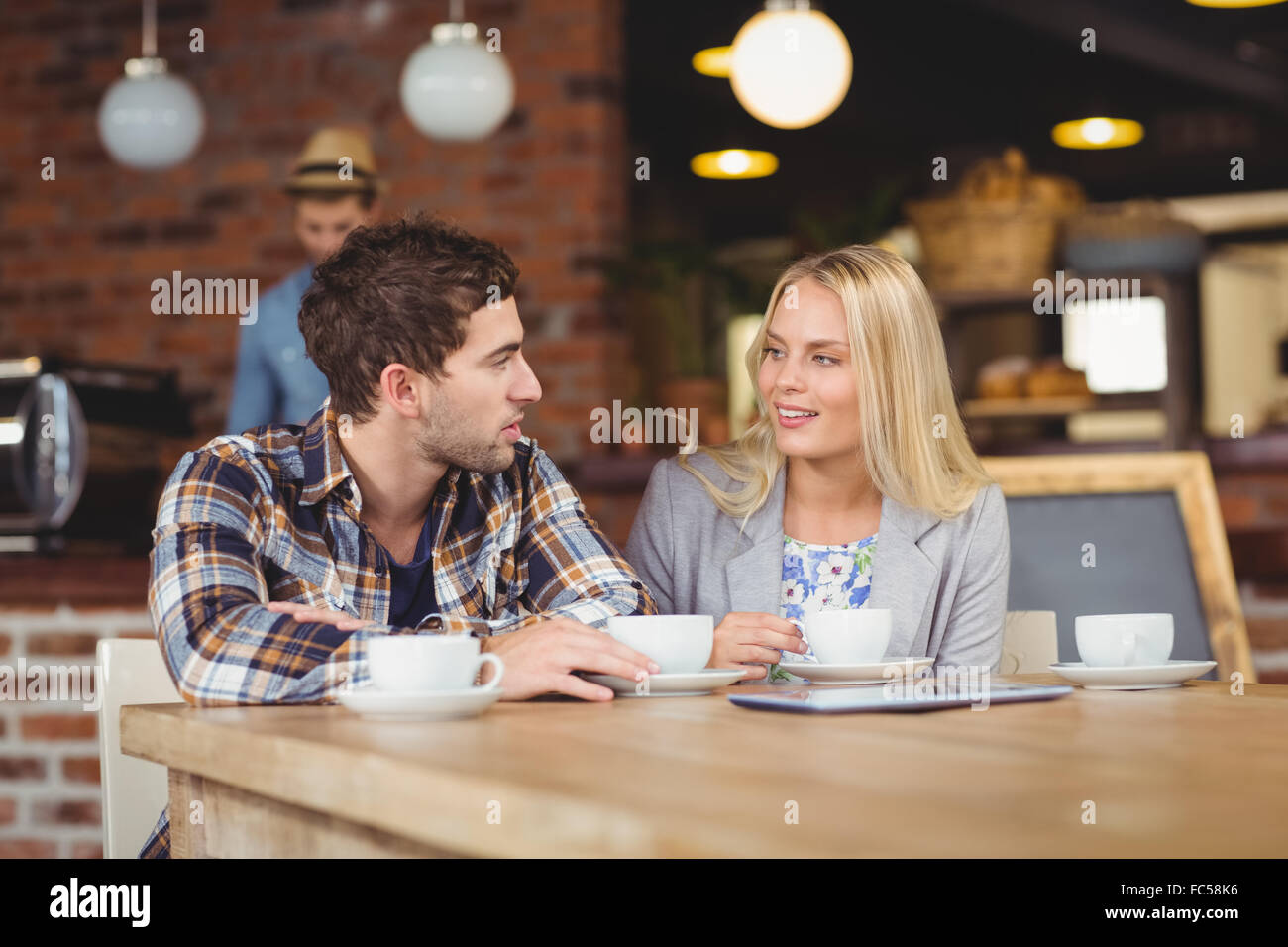 Two smiling friends talking and drinking coffee Stock Photo - Alamy