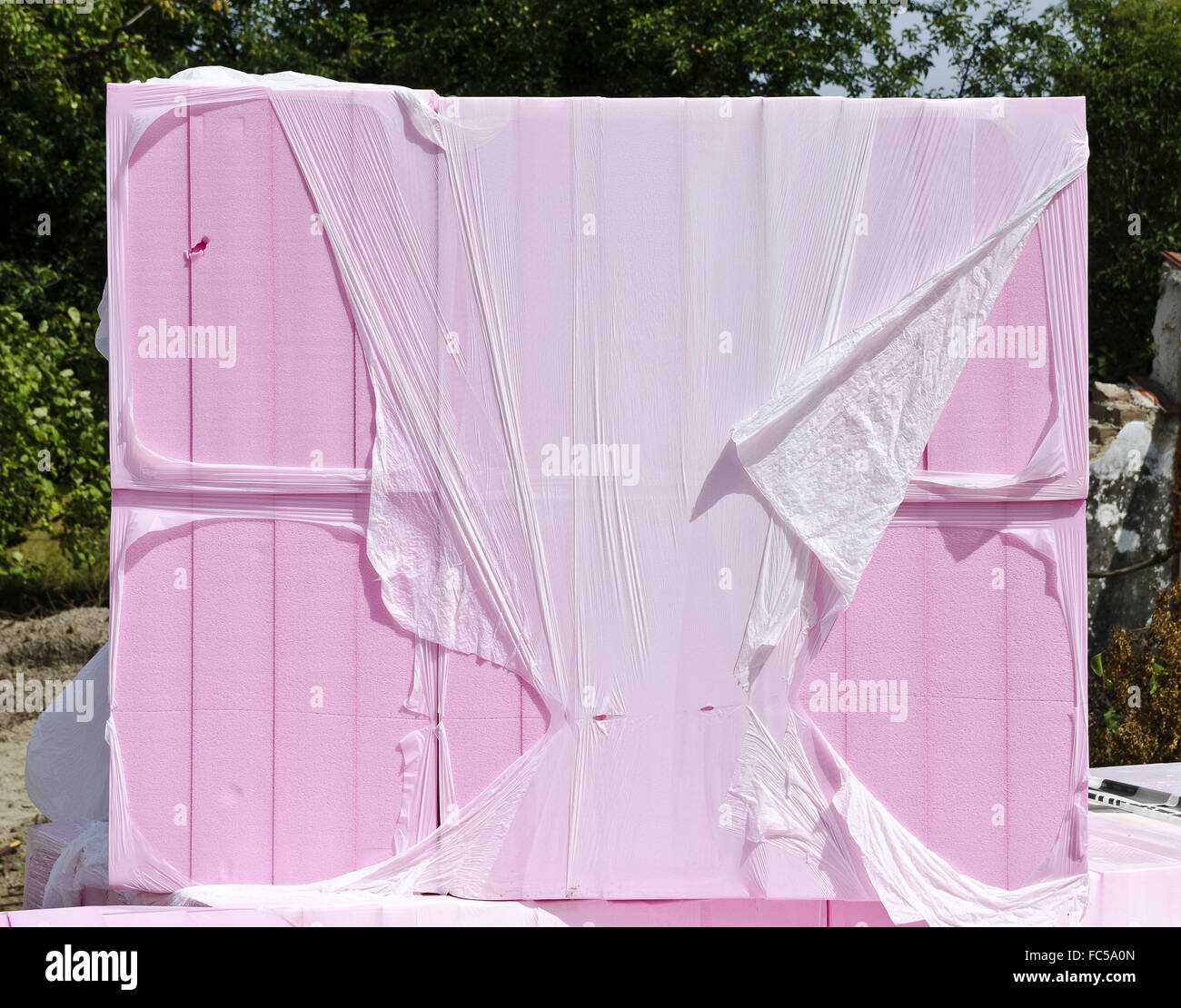 bundle of pink insulating boards wrapped Stock Photo - Alamy
