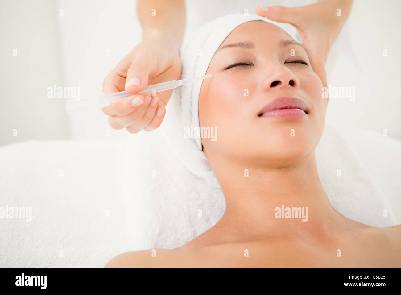 Optician administering eye liquid to her patient Stock Photo - Alamy