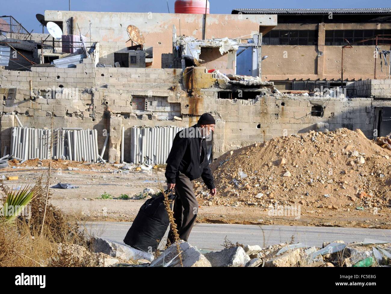 Damascus. 20th Jan, 2016. A Syrian man arrives with his belongings at ...