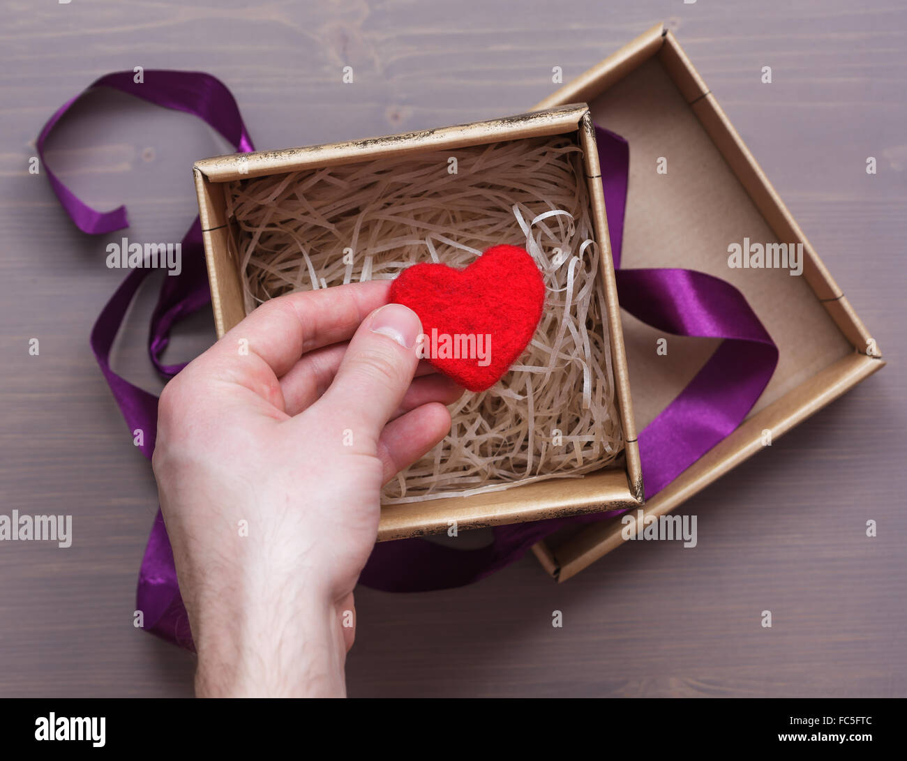 Man holding red heart in box for gift Stock Photo - Alamy