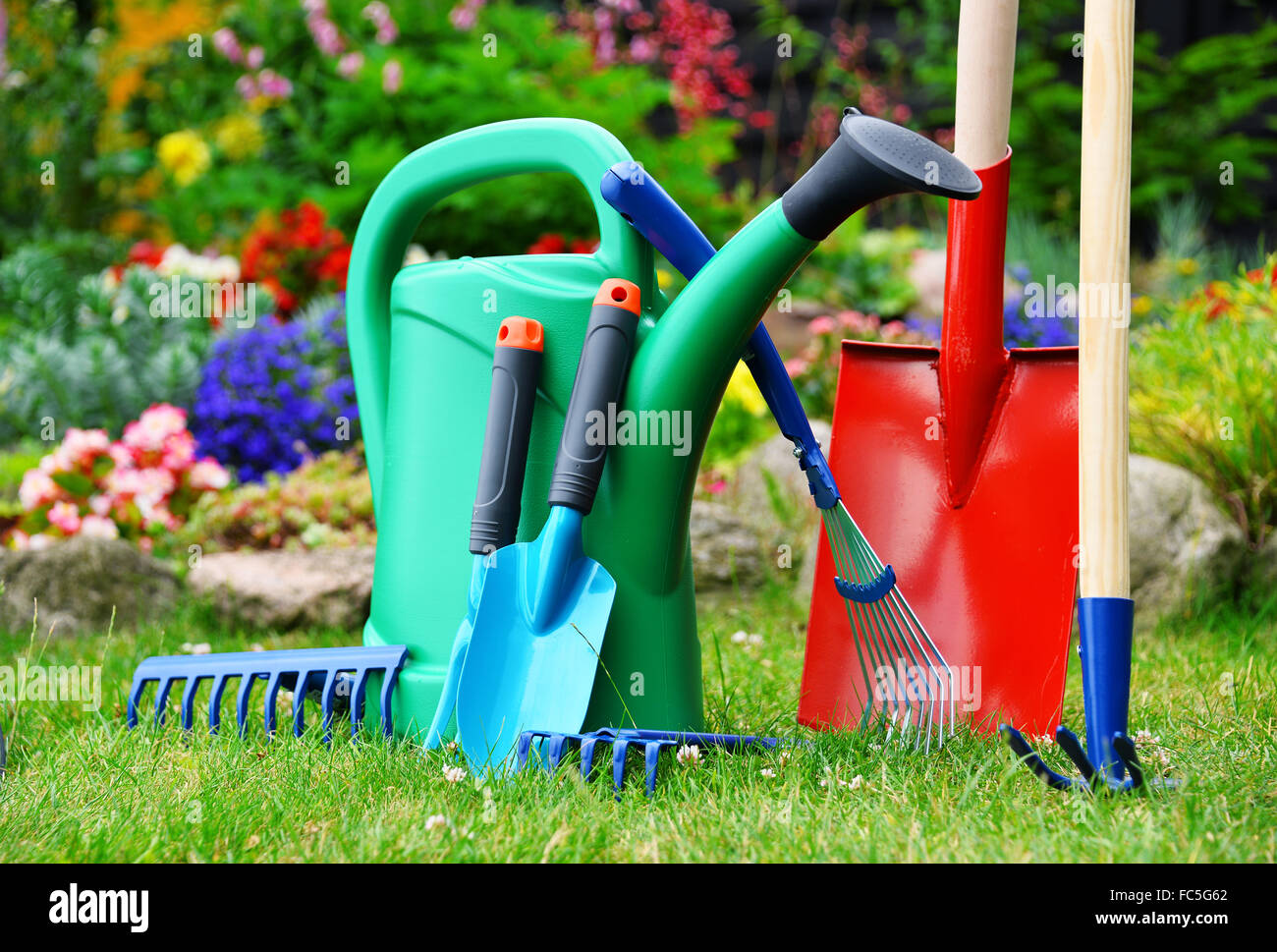 Watering can and tools in the garden Stock Photo - Alamy