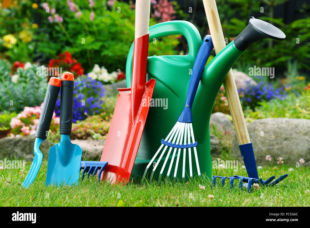 Watering can and tools in the garden Stock Photo - Alamy