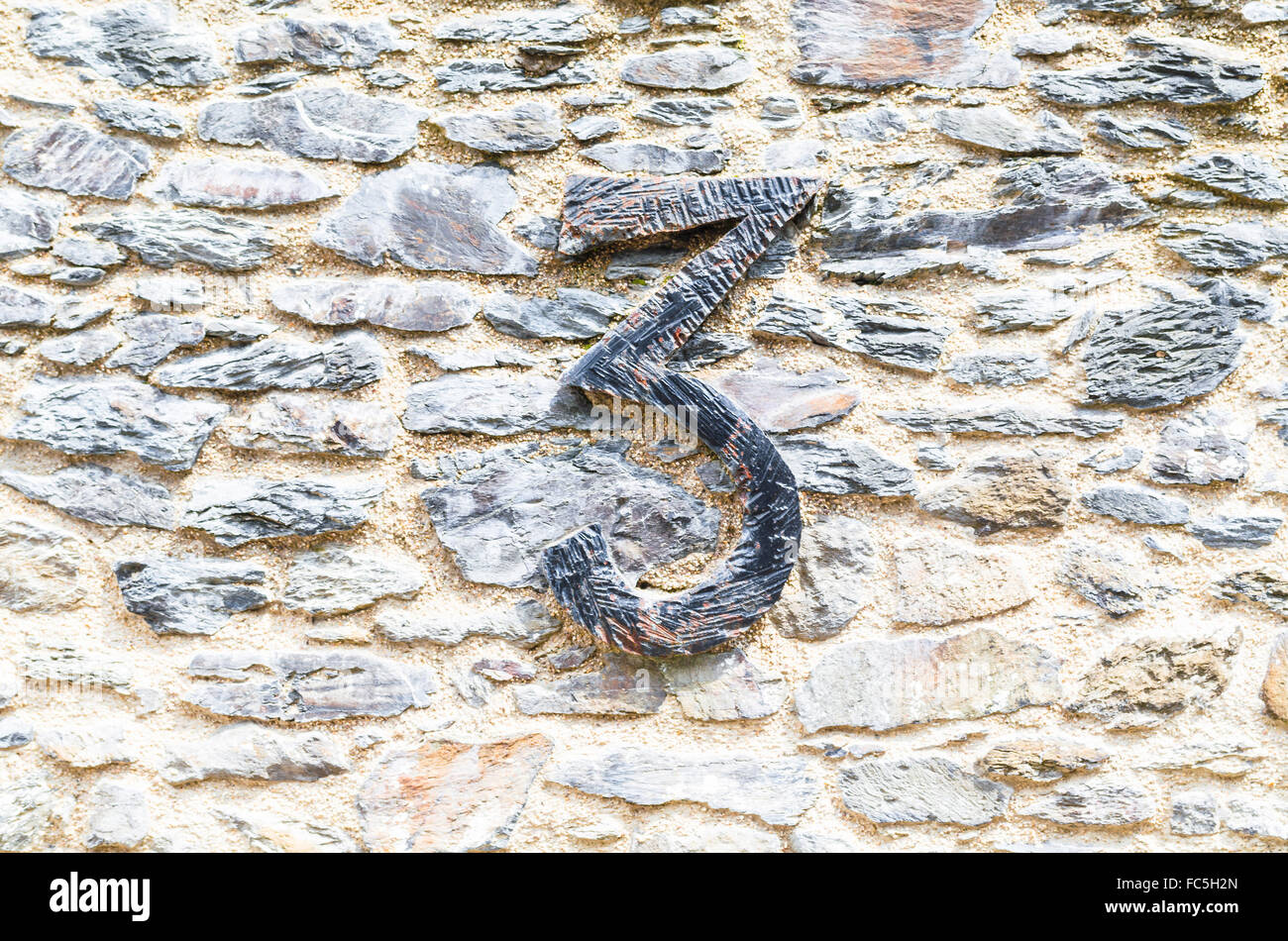 Stone wall with wrought iron number Stock Photo - Alamy