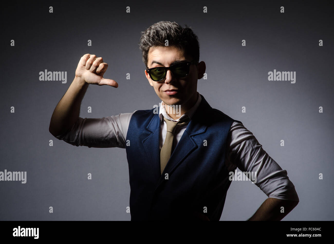 Young man in blue vest against gray Stock Photo - Alamy