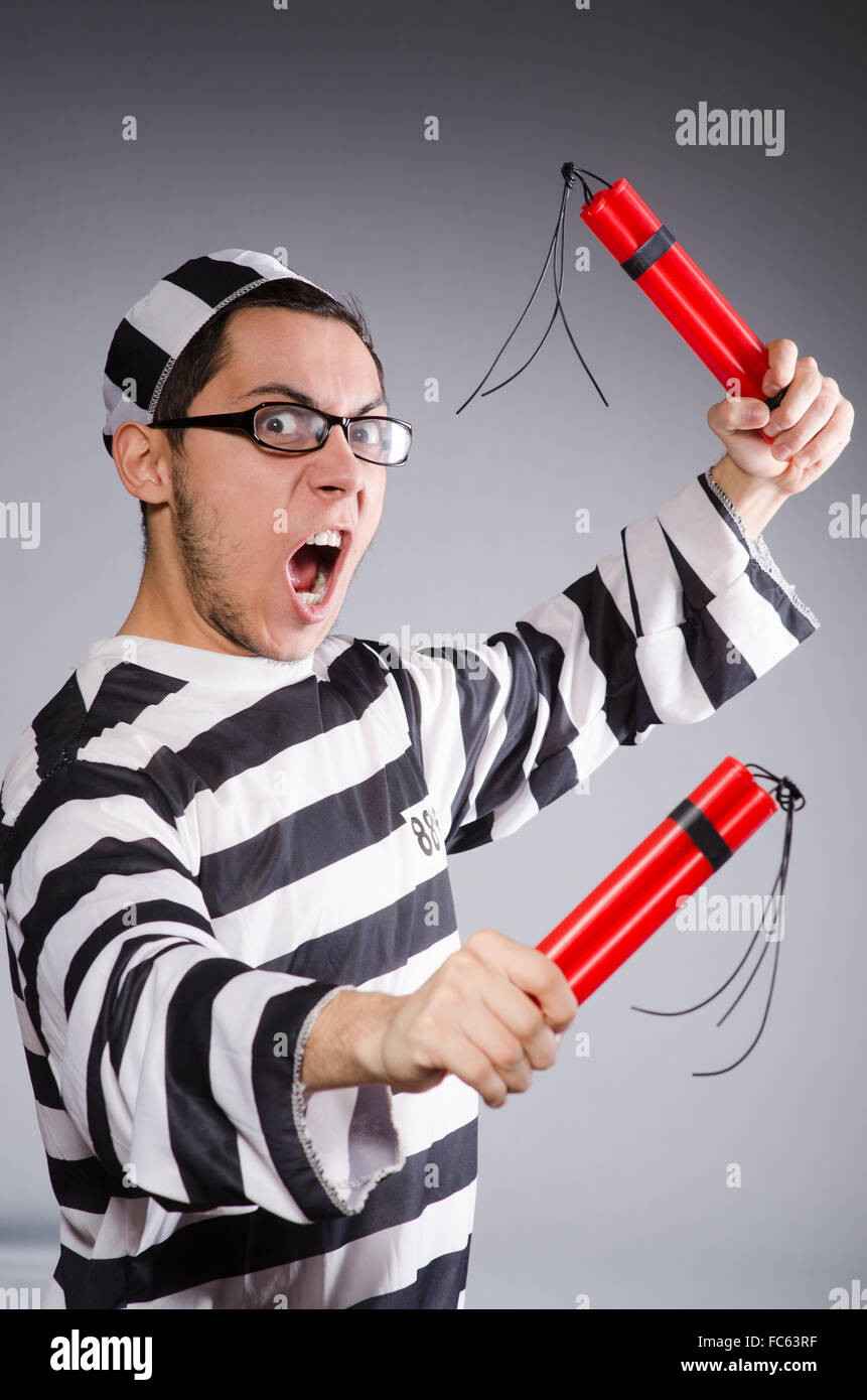 Young prisoner holding dynamite against gray Stock Photo - Alamy
