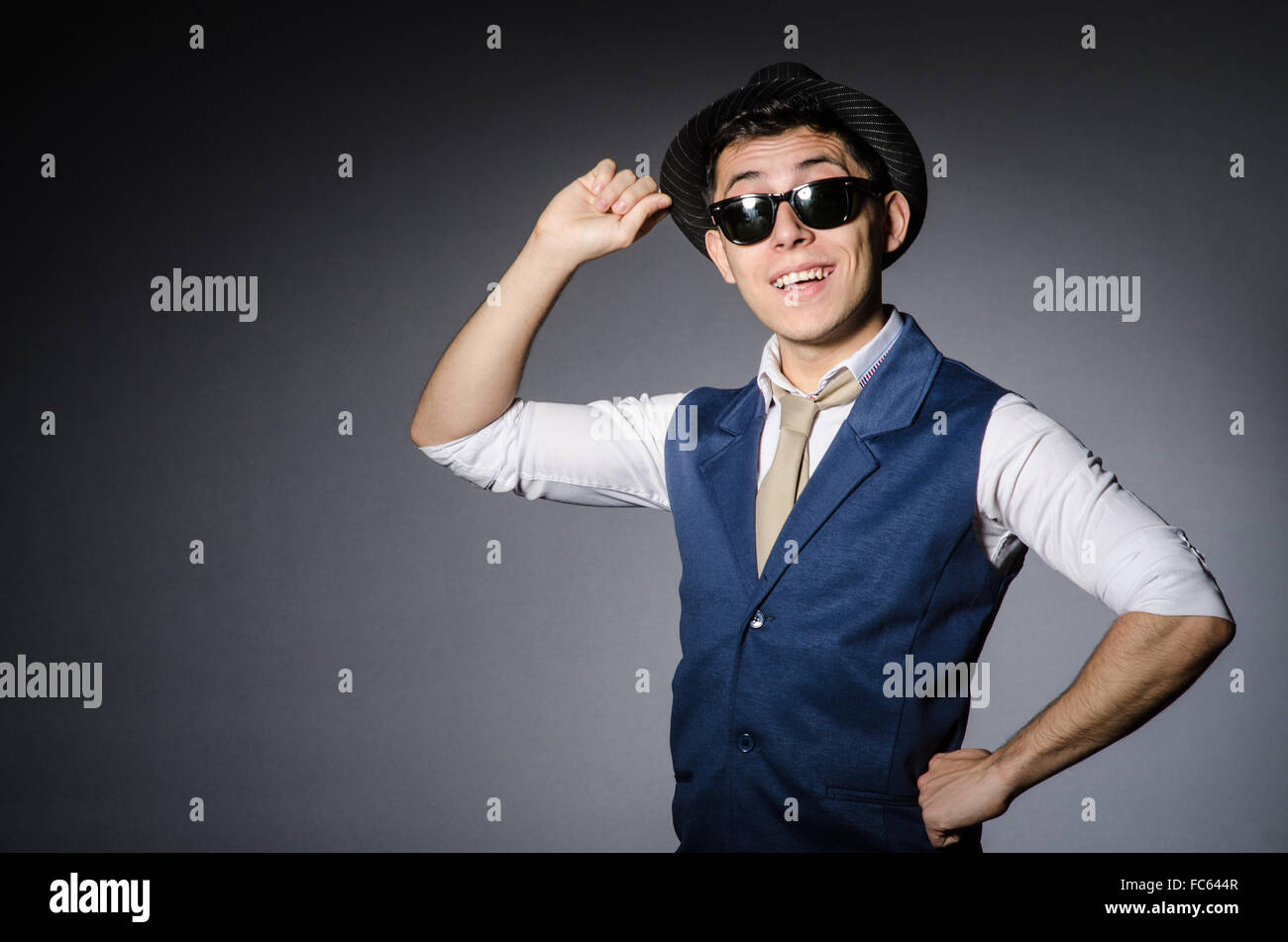 Young man in blue vest and hat against gray Stock Photo - Alamy