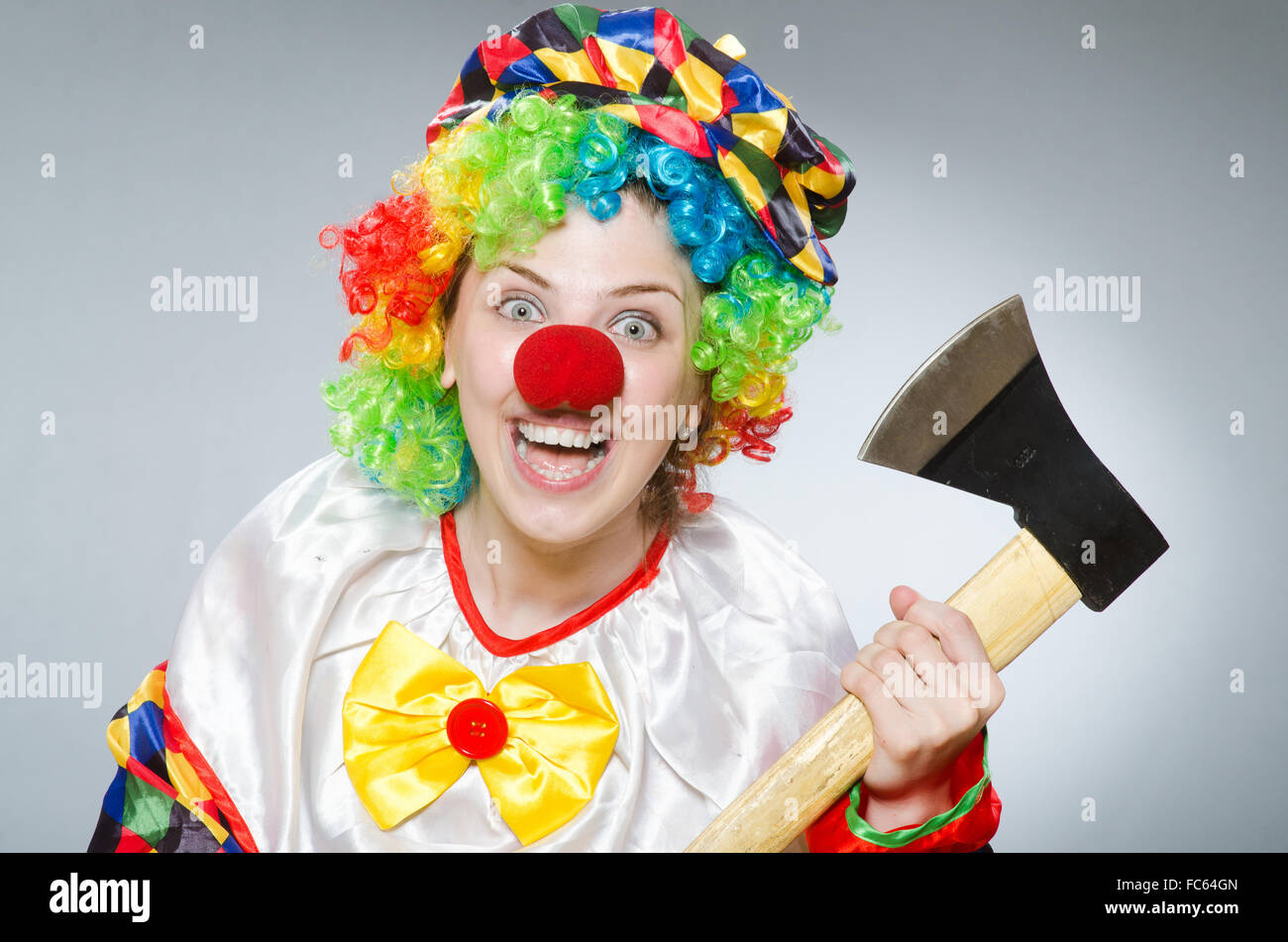 Clown with axe in funny concept Stock Photo - Alamy
