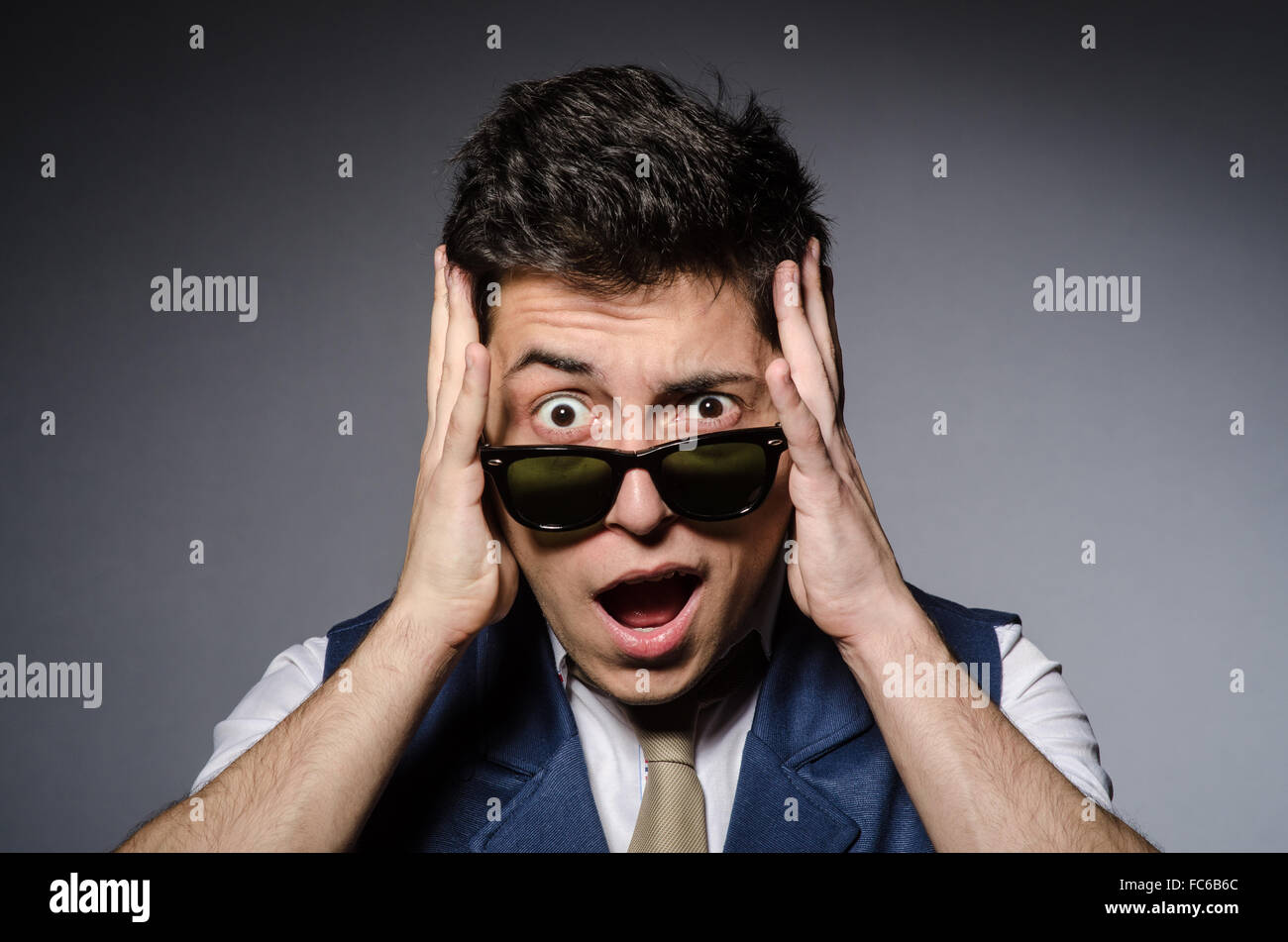 Young man in blue vest against gray Stock Photo - Alamy