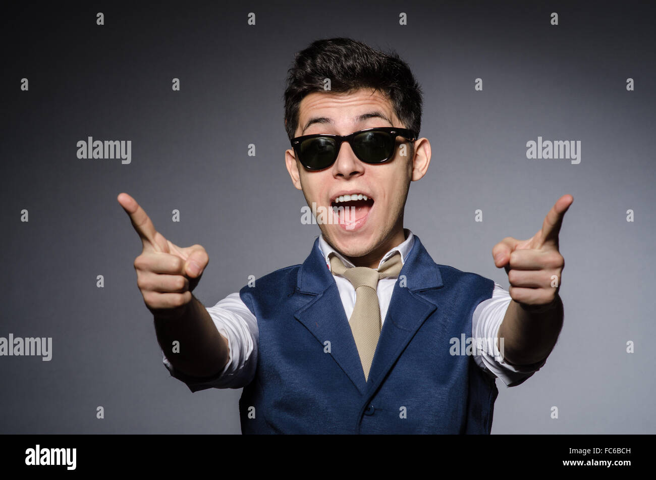 Young man in blue vest against gray Stock Photo - Alamy