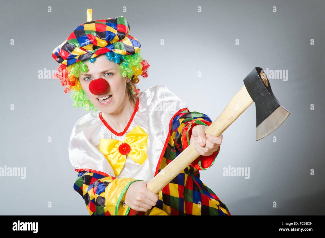 Clown with axe in funny concept Stock Photo - Alamy
