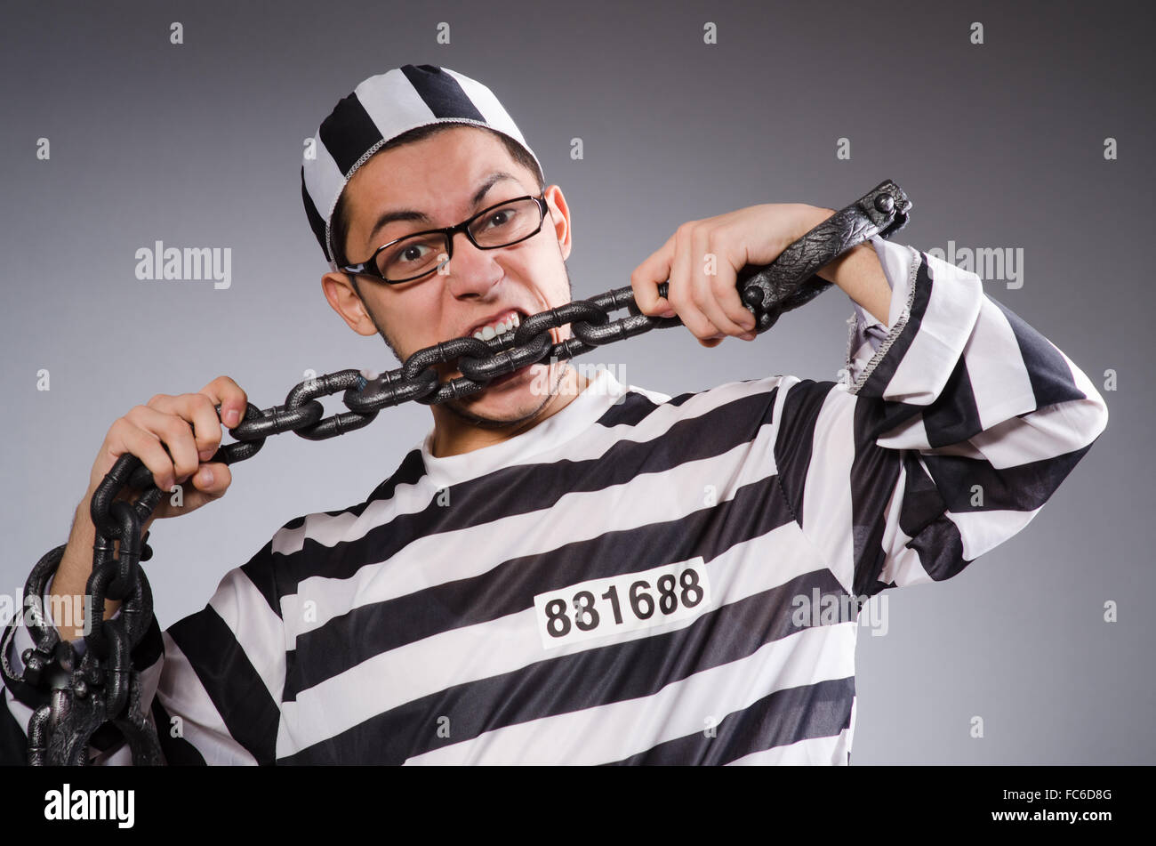Young prisoner in chains against gray Stock Photo - Alamy