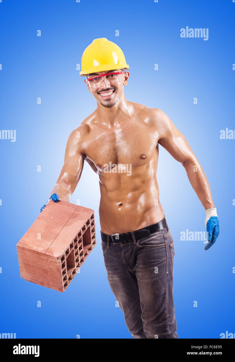 Muscular builder with bricks on white Stock Photo - Alamy