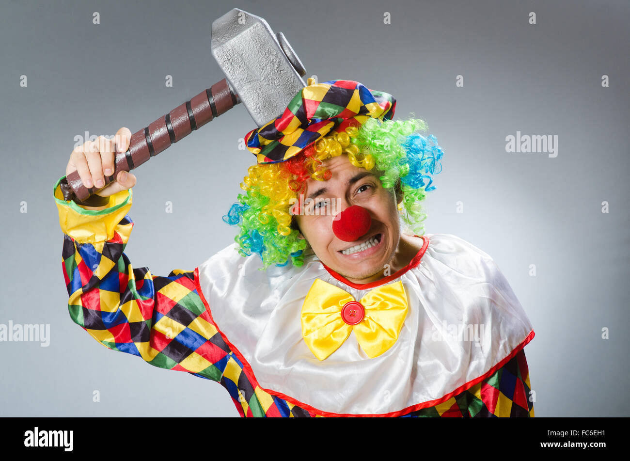 Clown with hammer in funny concept Stock Photo - Alamy