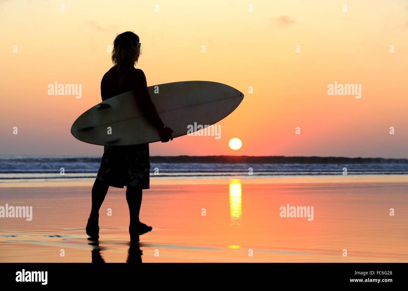 Surfer on sunset Stock Photo - Alamy