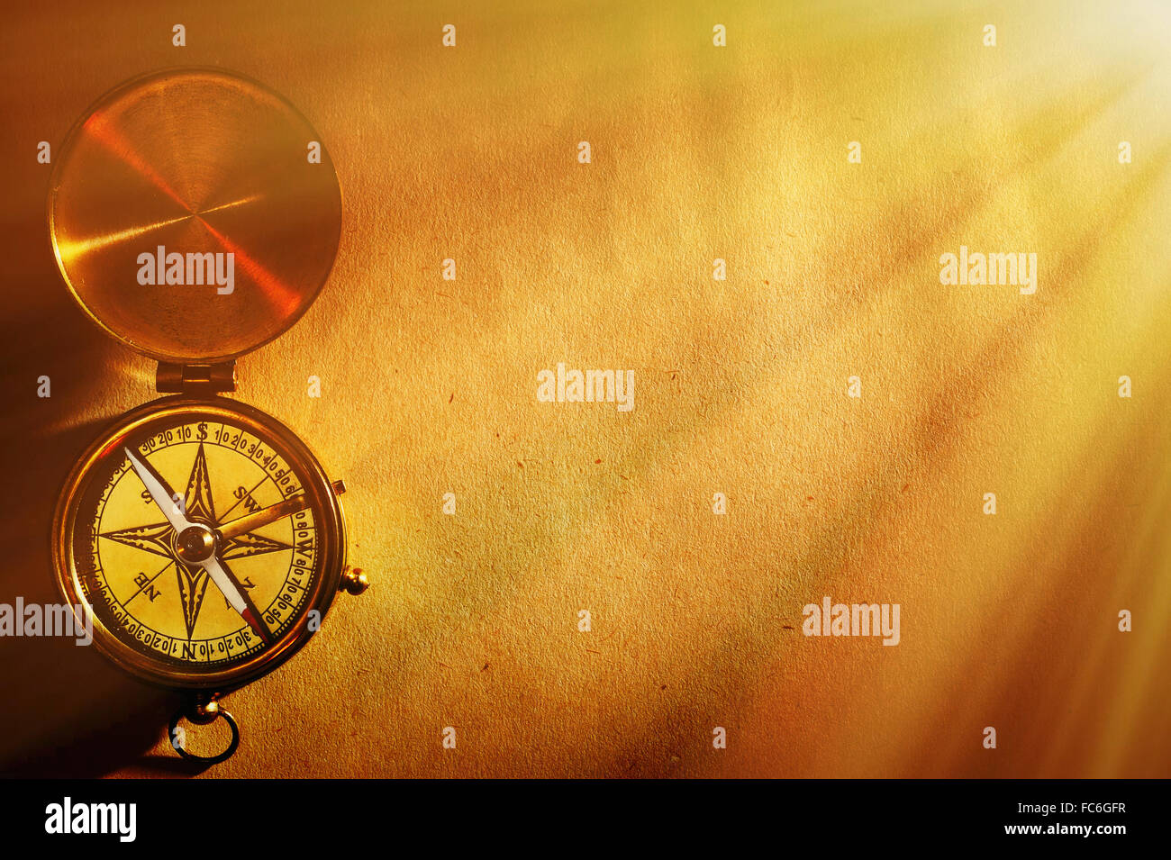 Antique brass compass over old background Stock Photo - Alamy